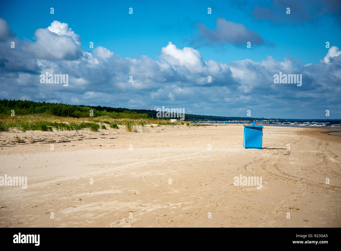 empty sea beach in spring with some birds and cargo ships on the ...