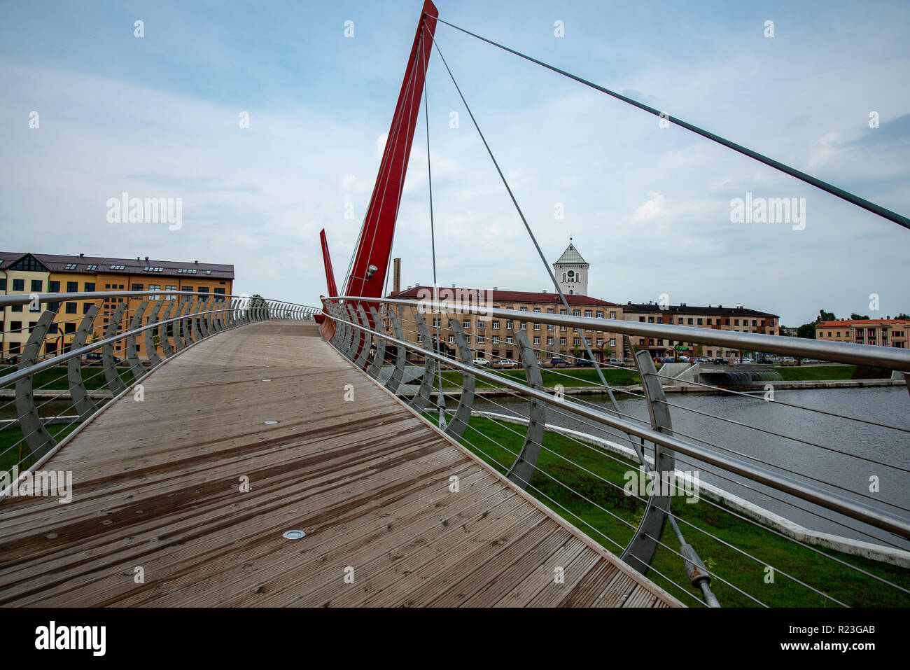 wooden and composite material foot bridge over water in green summer ...