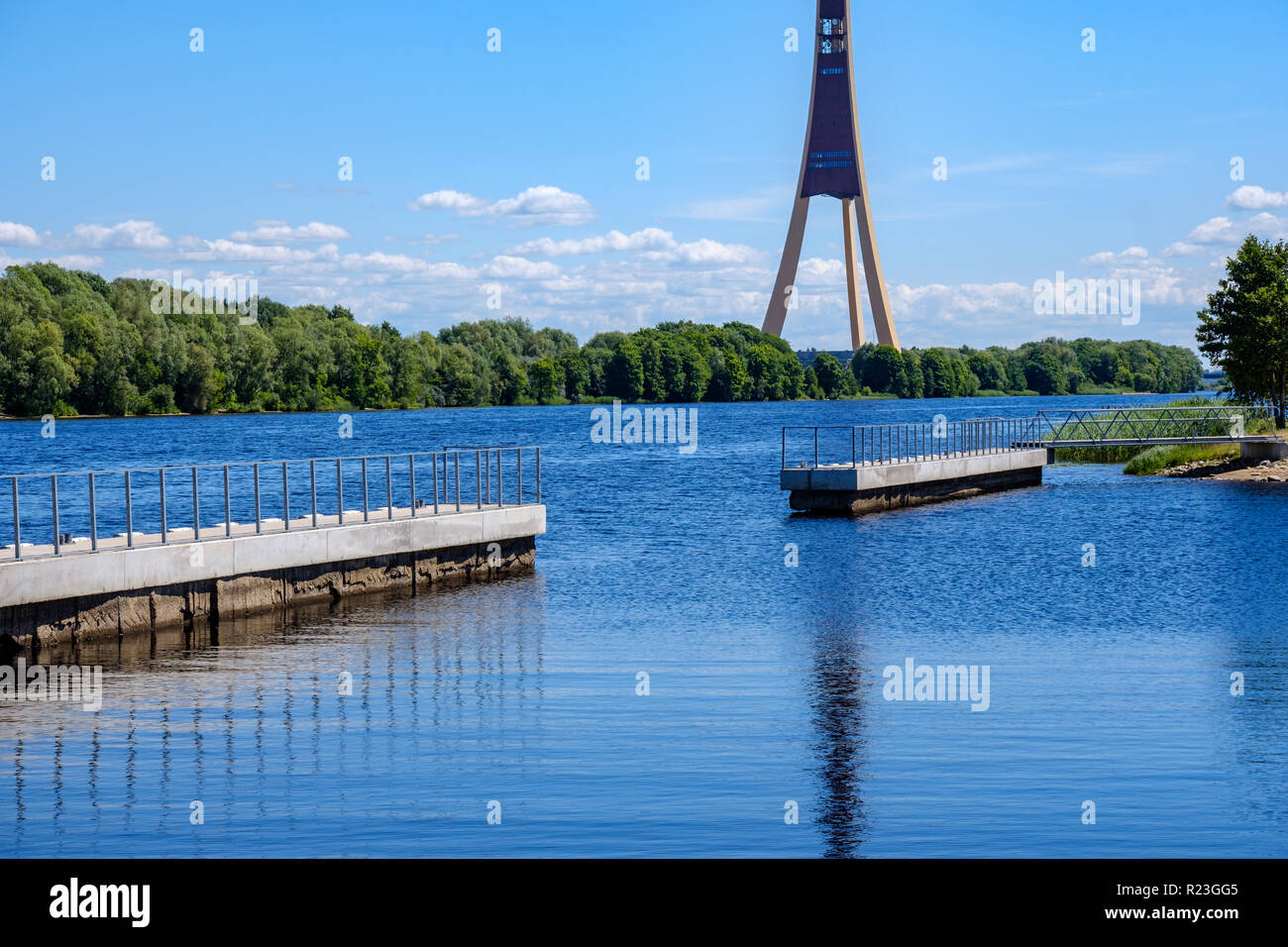 wooden and composite material foot bridge over water in green summer ...