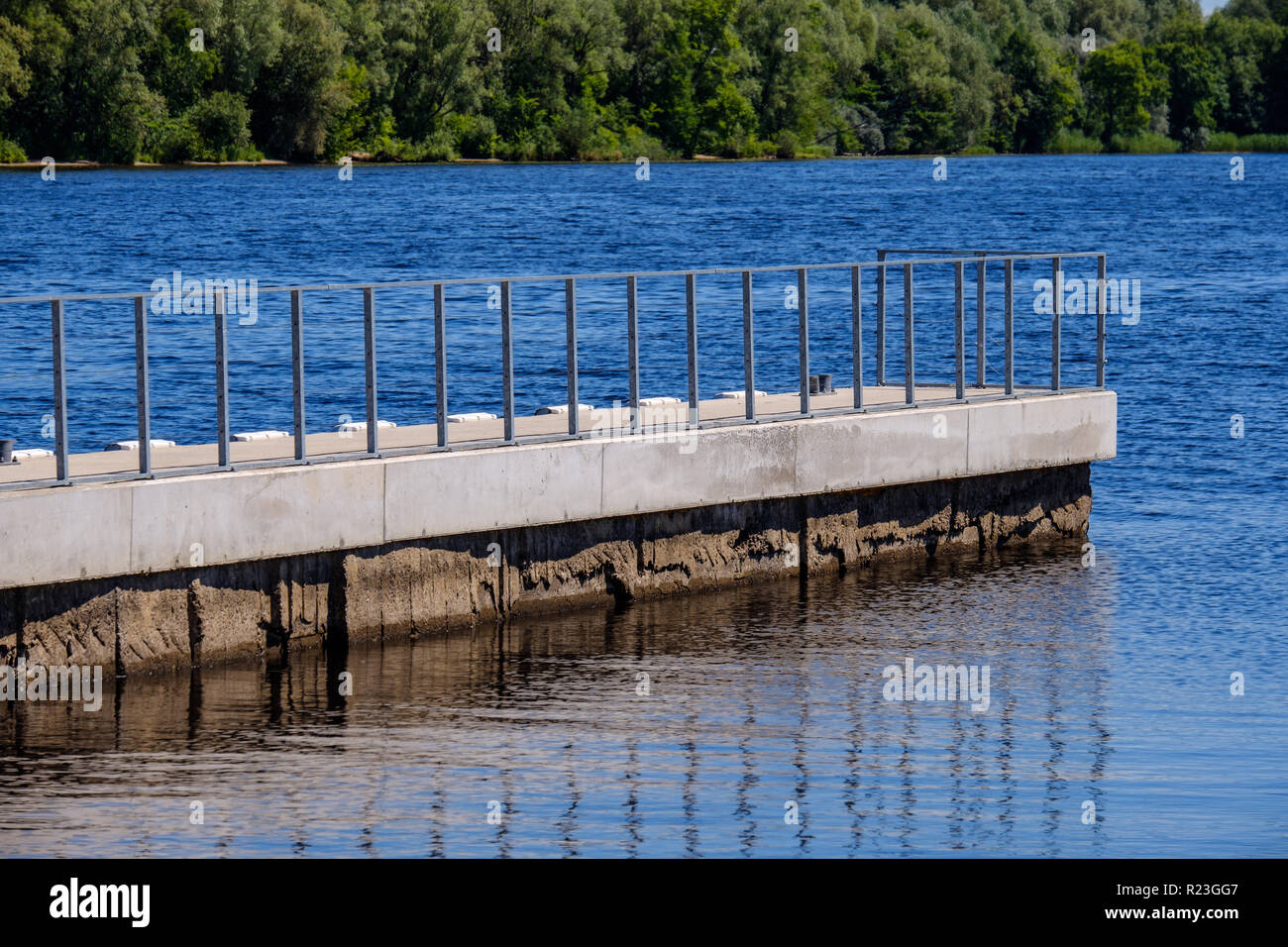 wooden and composite material foot bridge over water in green summer ...