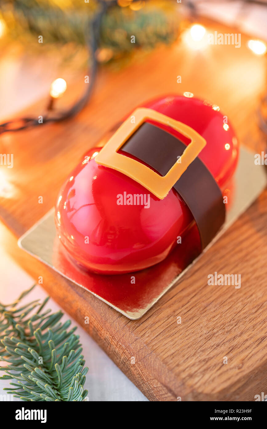 Mini mousse pastry dessert with red glazed on garland lamps bokeh ...