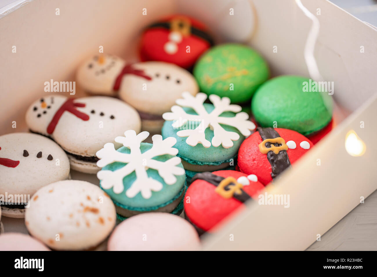 Variety of sweet macaroons in white box. The branches of spruce on ...