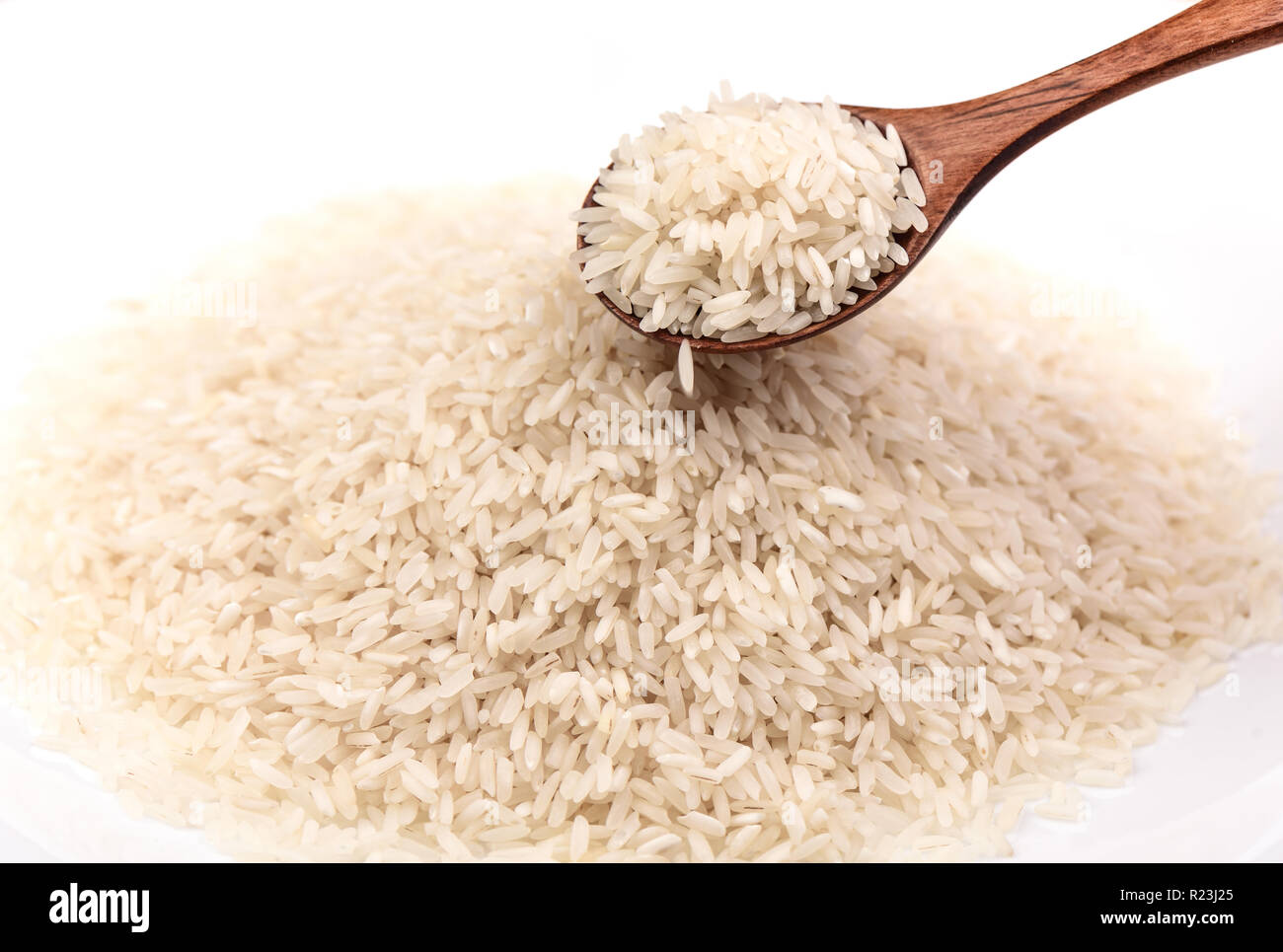 Wooden spoon of long grain rice over rice. Grocery concept. Close up ...
