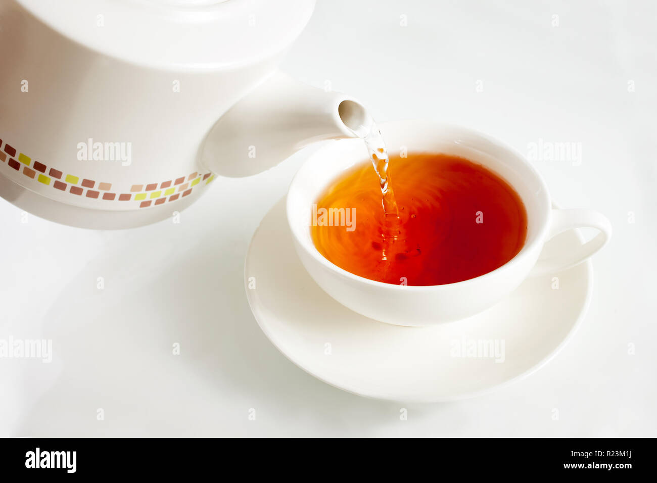 Pouring boiling water into a tea cup from white kettle Stock Photo - Alamy