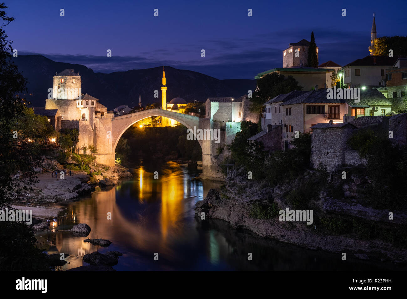Night time view of the city of Mostar lit up along the river, featuring ...