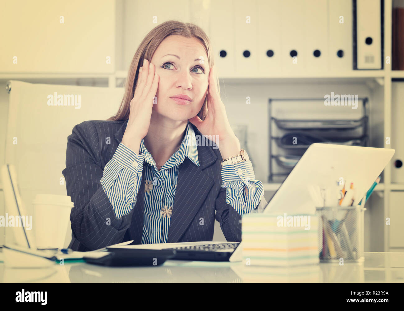 Frustrated business woman sitting at office desk with notebook Stock Photo - Alamy