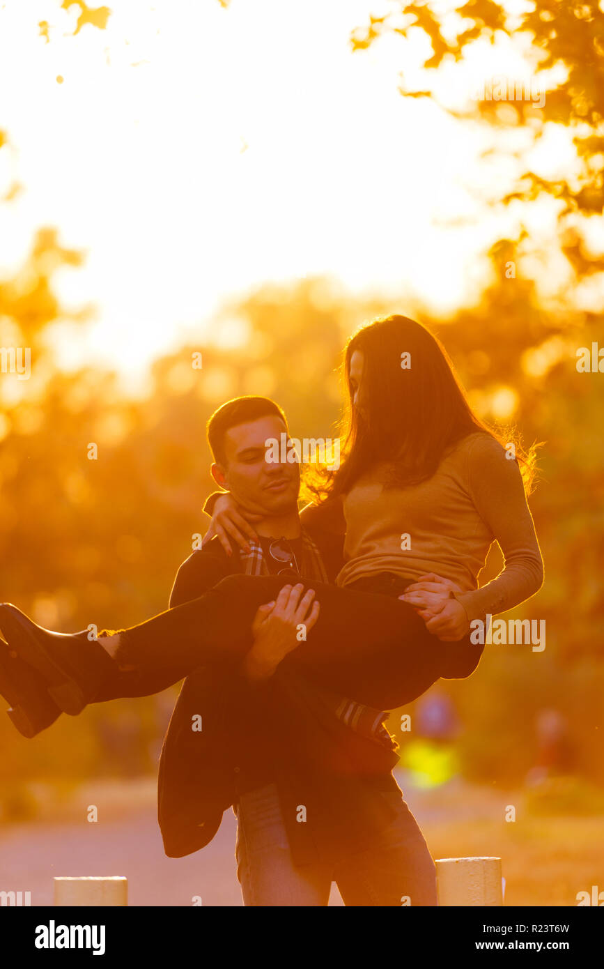 Strong boyfriend carrying his girlfriend on his back at sunset Stock ...