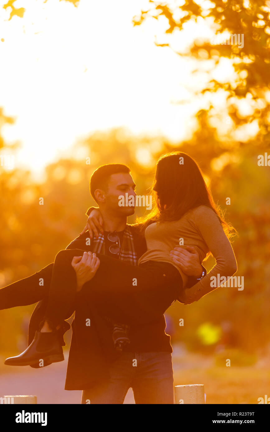 Strong boyfriend carrying his girlfriend on his back at sunset Stock ...