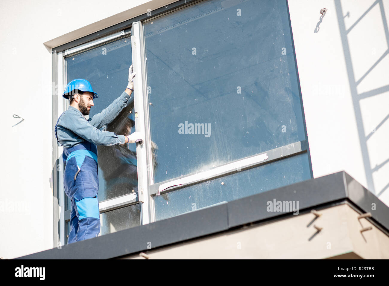 Workman in uniform mounting windows checking the vertical level ...