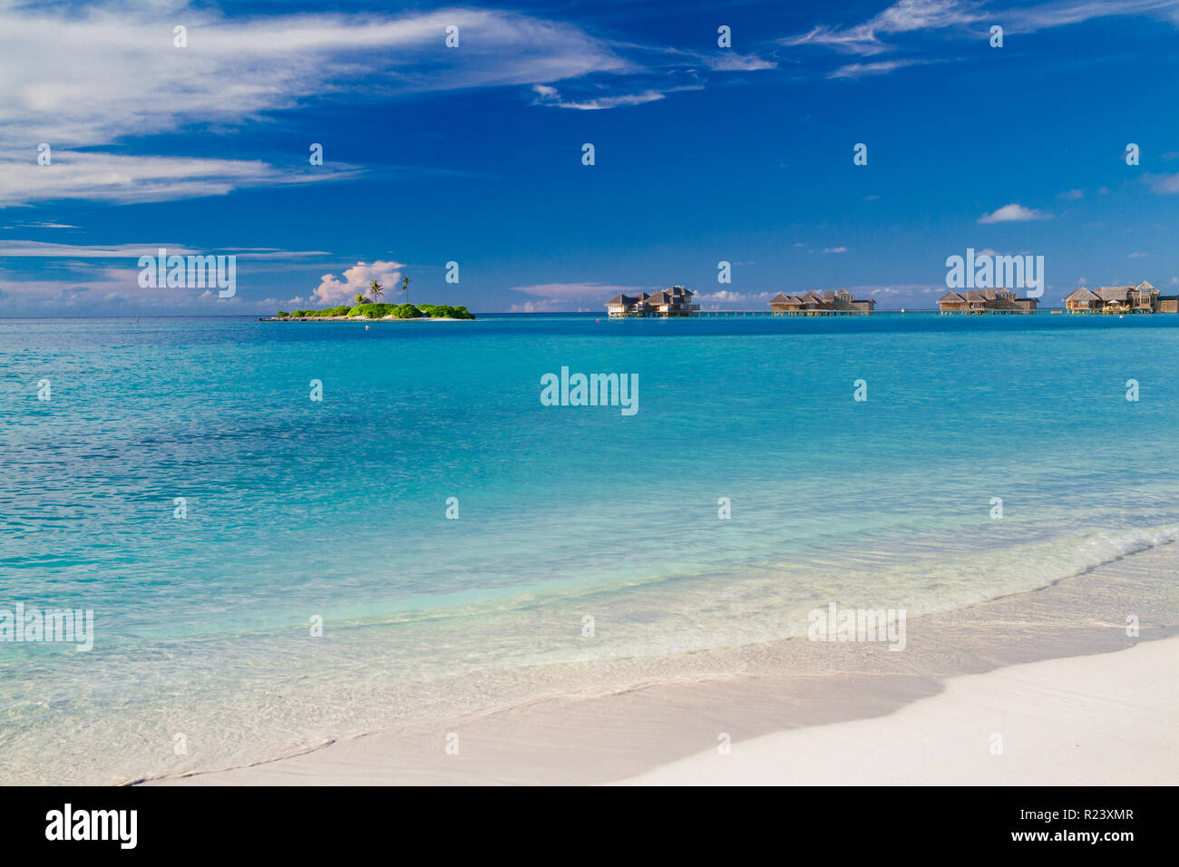 Tropical island with sandy beach, turquoise clear water and over water ...