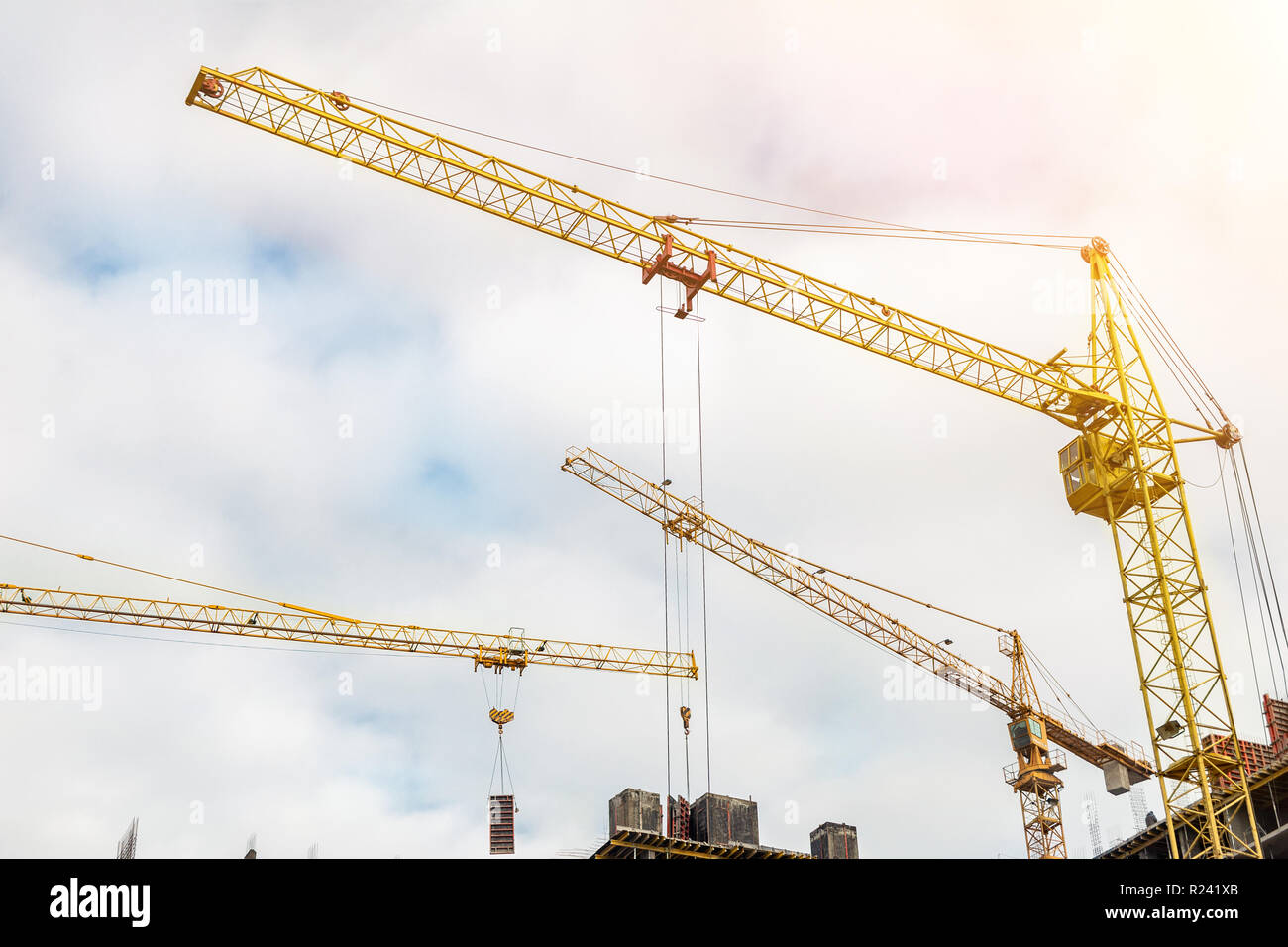 Many cranes and buildings against blue sky. Construction site of ...