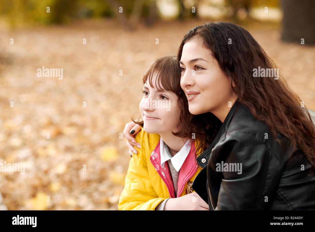 Two girls are in autumn city park Stock Photo - Alamy