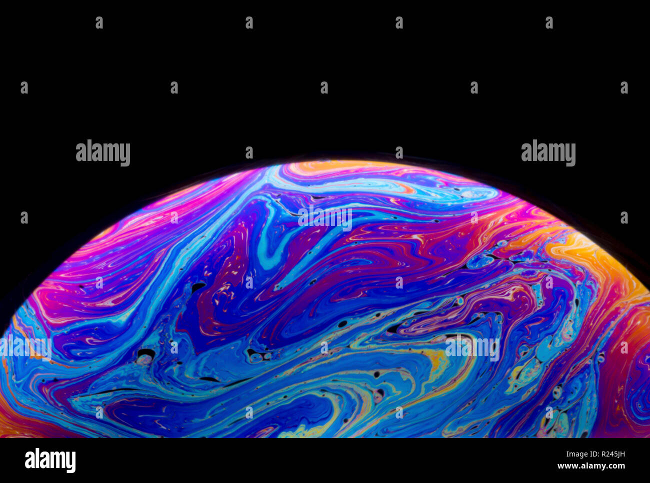 Close up rainbow colours in a soap bubble that look like space or ...