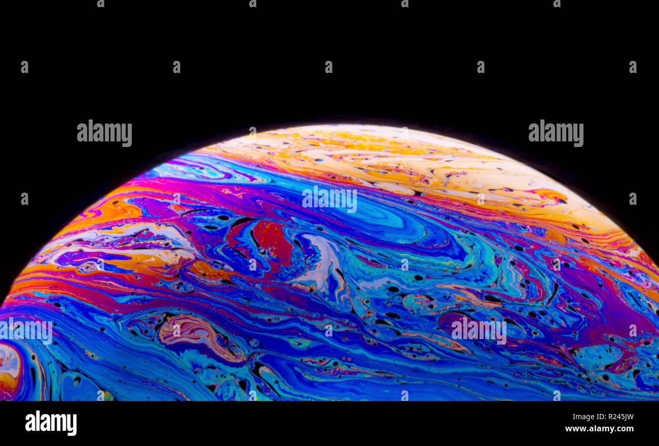 Close up rainbow colours in a soap bubble that look like space or ...