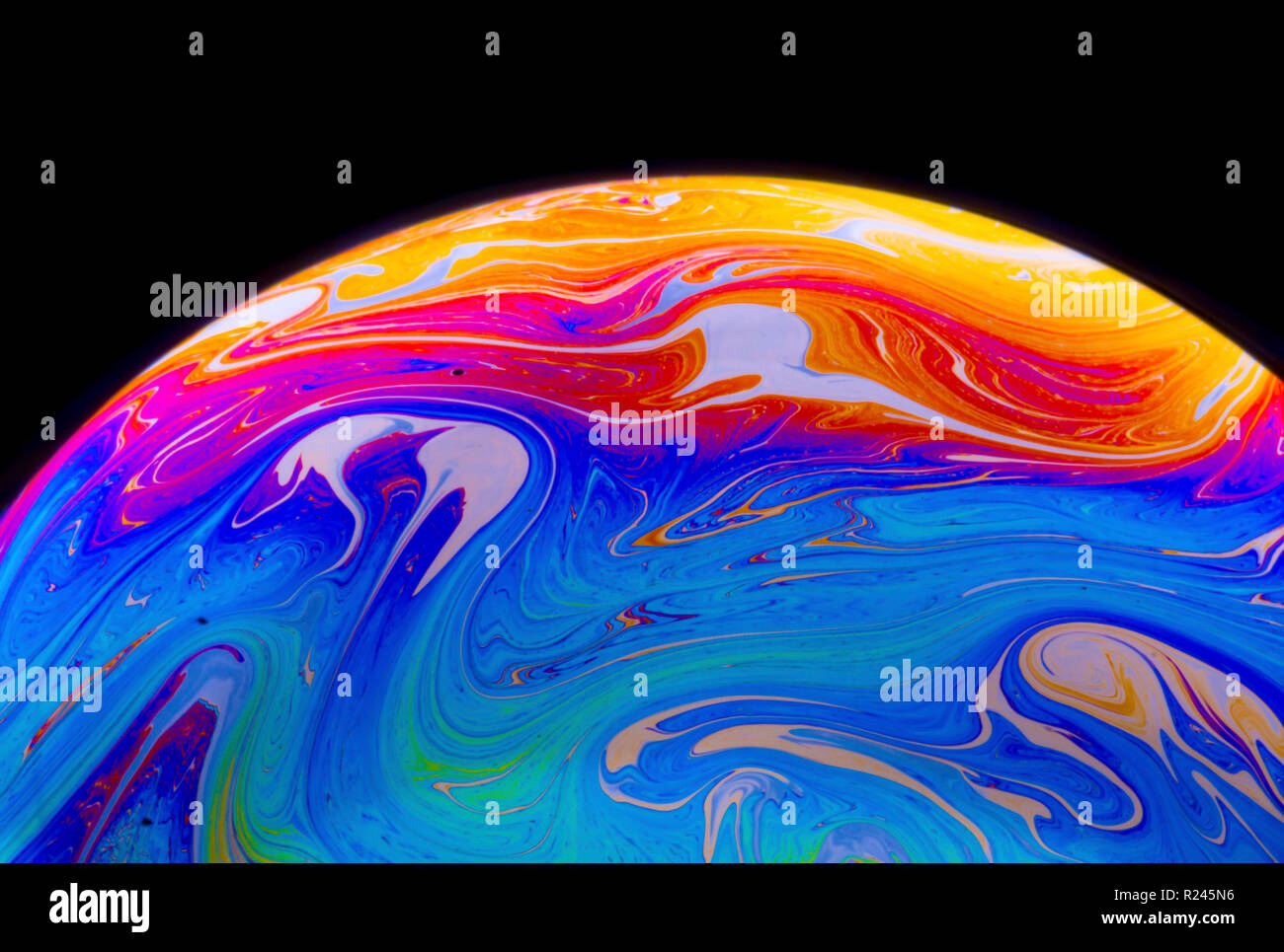 Close up rainbow colours in a soap bubble that look like space or ...