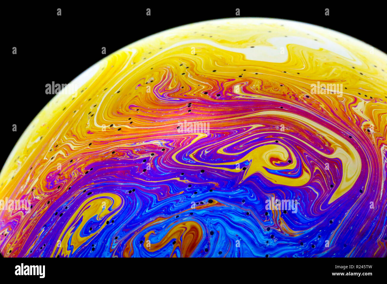 Close up rainbow colours in a soap bubble that look like space or ...