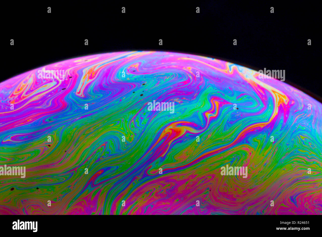 Close up rainbow colours in a soap bubble that look like space or ...