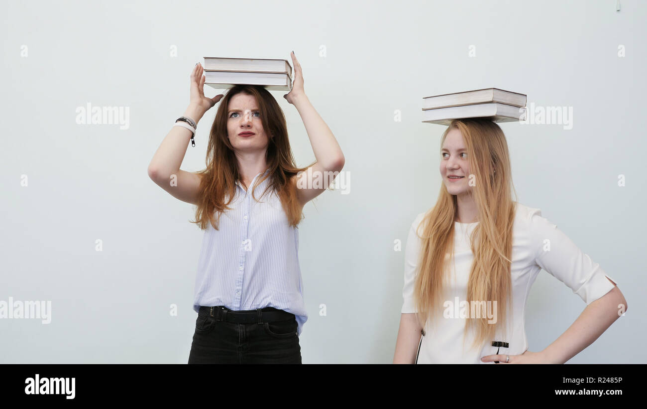 Two schoolgirls play with books holding them on their heads Stock Photo ...