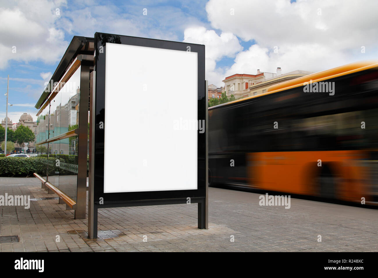 Bus stop with blank billboard, with blurred motion bus Stock Photo - Alamy