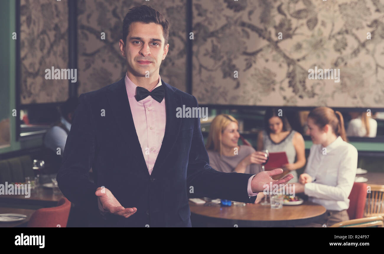 Polite confident waiter inviting to visit modern urban restaurant Stock ...