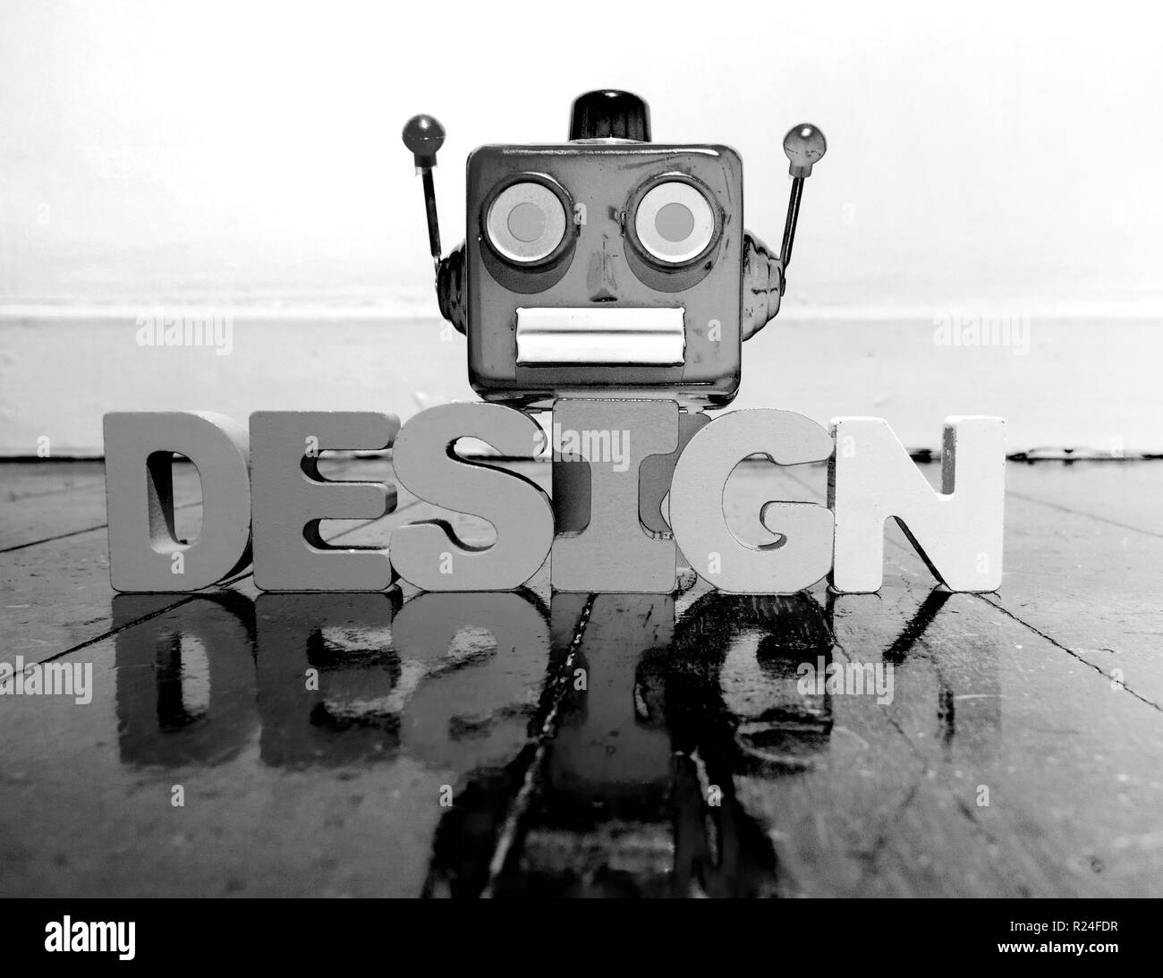red retro robot head on the word DESIGN on old wooden floor with ...