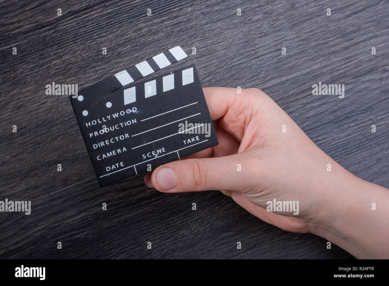Hand holding movie clapper on a dark background Stock Photo - Alamy