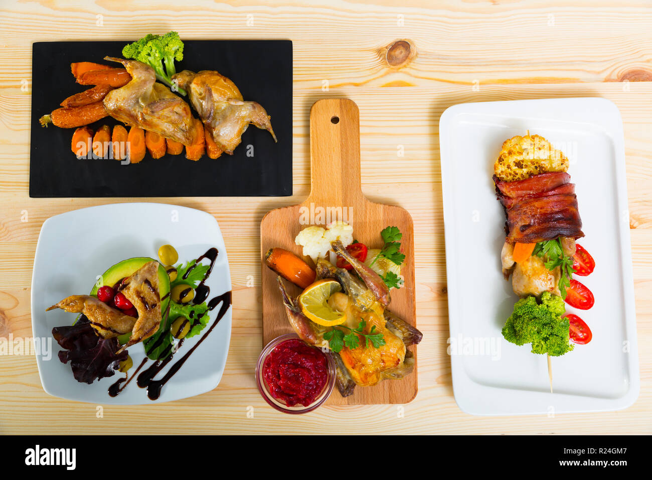 Top view of various game dishes beautifully served on plates and wooden ...