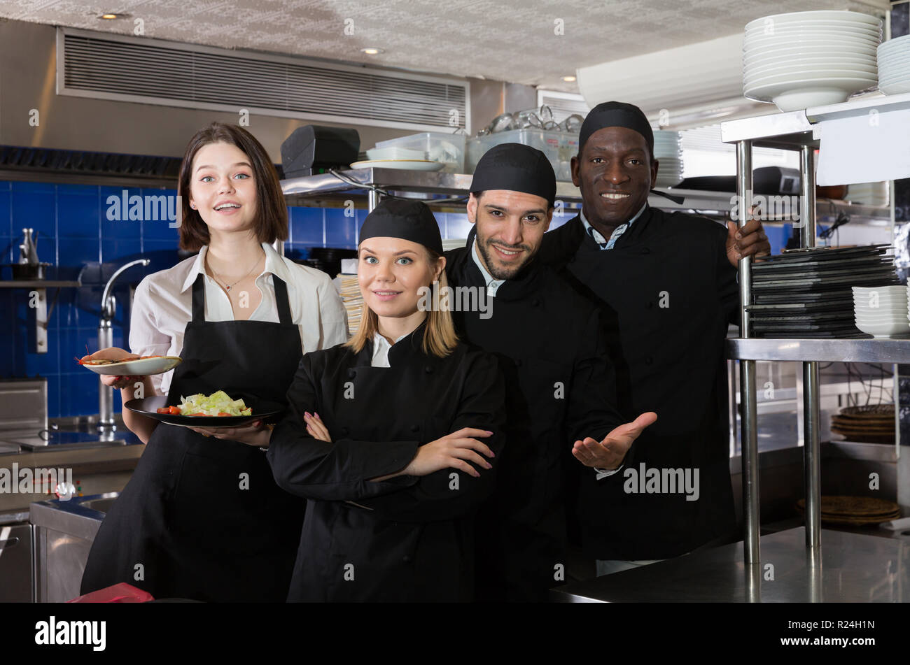 Woman waiter with kitcheners are standing together on kitchen in ...