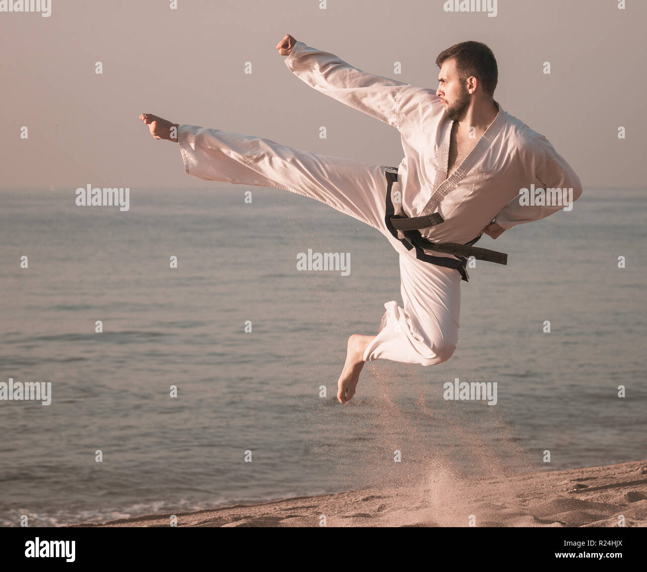 Positive man doing karate at ocean quay in dawn Stock Photo - Alamy