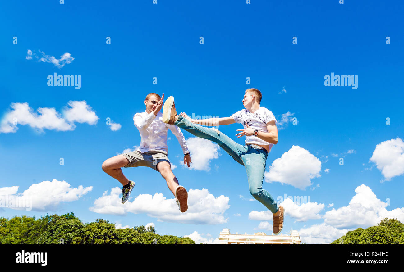 Guys are fighting in the air. Guys are jumping into air and kicking his ...