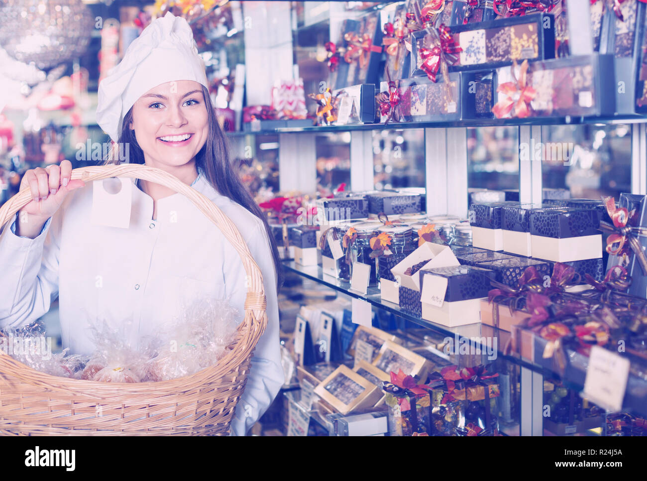 Young smiling woman selling gifts of fine chocolates and confectionery ...