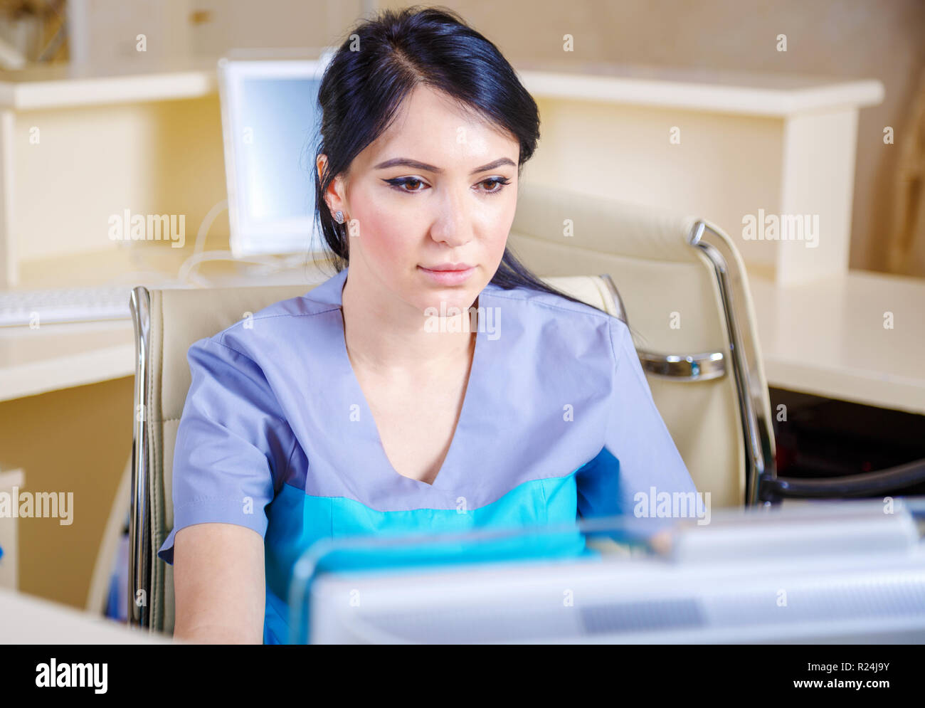 Female doctor sitting at the table. Beautiful young smiling female ...