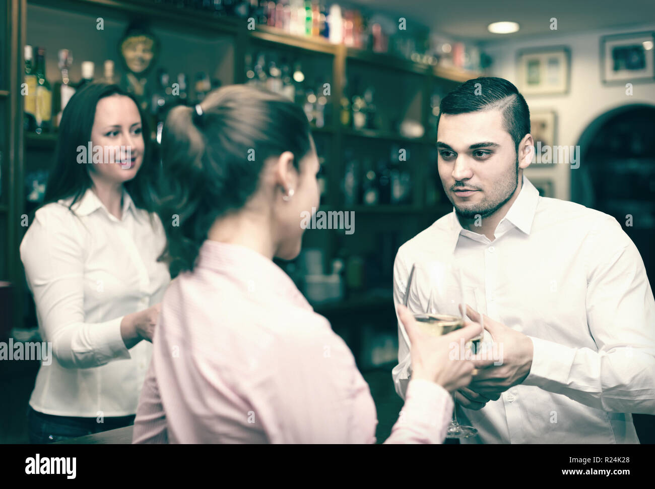 Small bar with smiling female barista and two clients at counter Stock ...