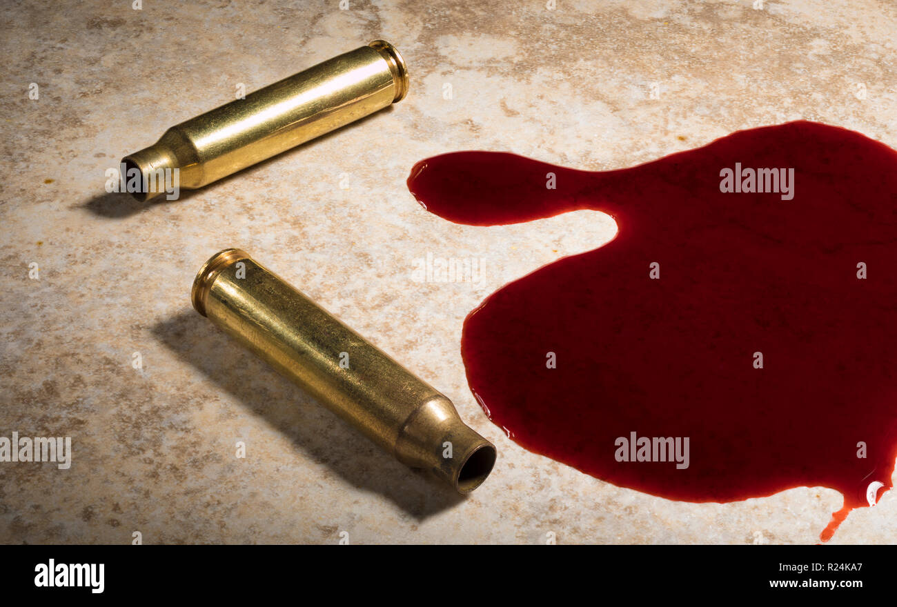 Pool of blood and pair of assault rifle rounds at a crime scene floor ...