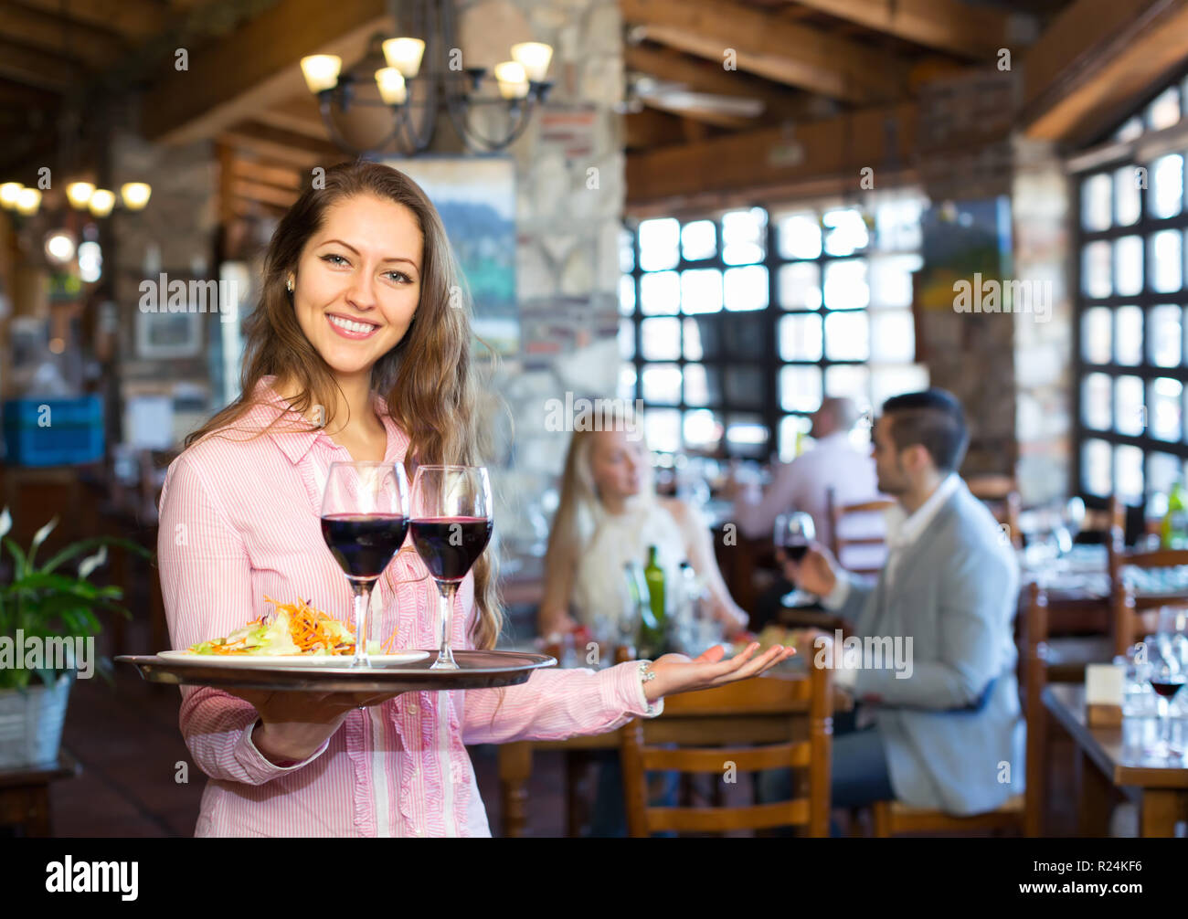 Portrait of cheerful adults having dinner and respectful waiter Stock ...