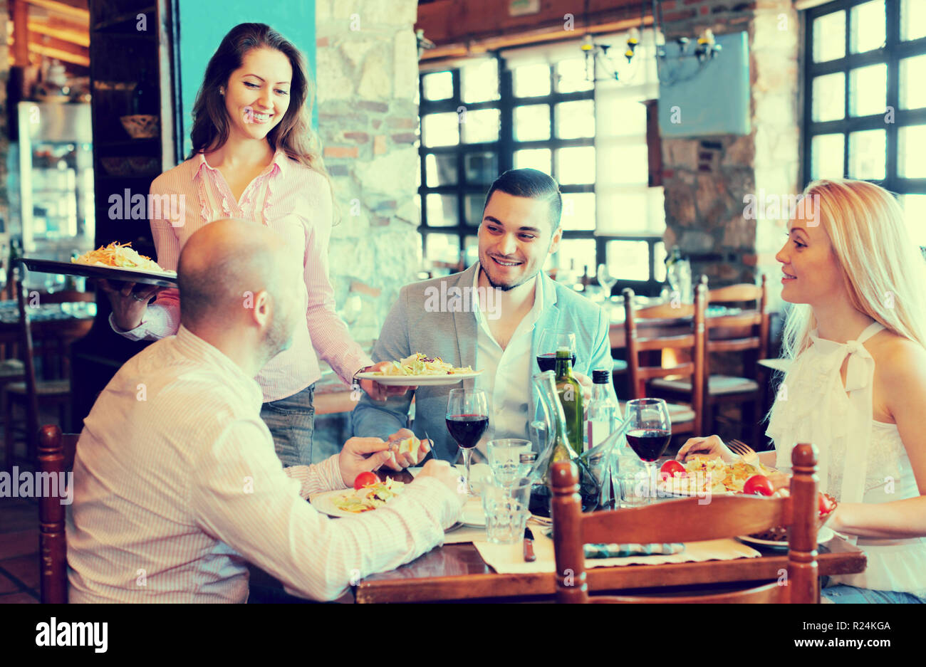 Smiling group people having dinner at rural restaurant. Focus on the ...