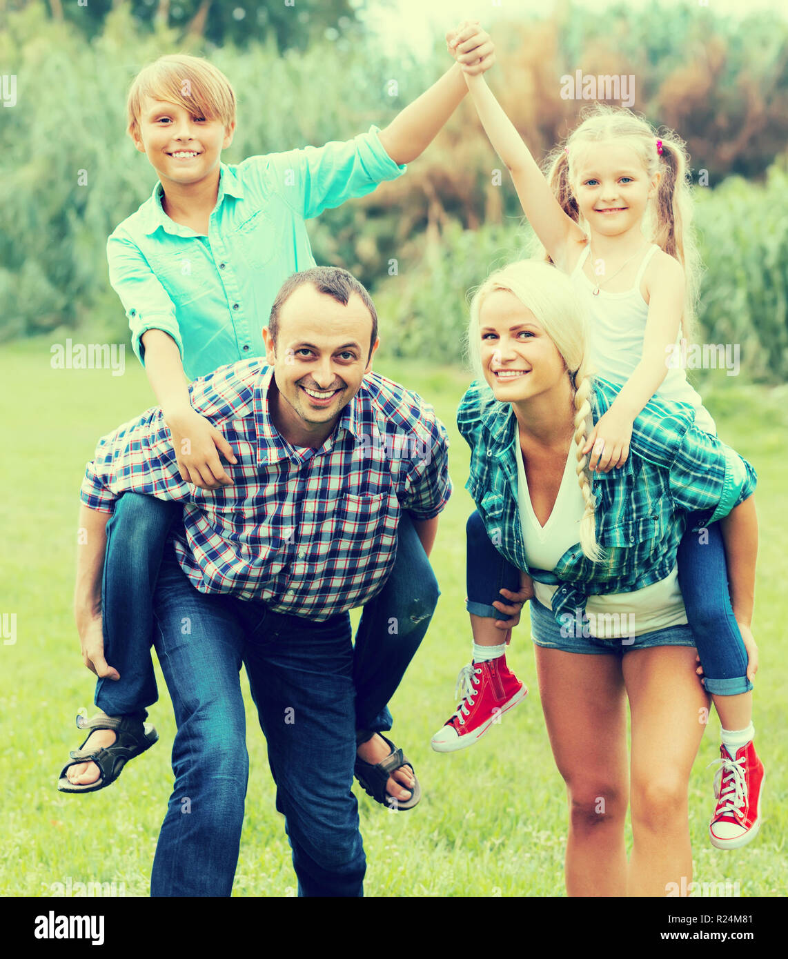 Positive family of four having fun at countryside in summer day Stock ...