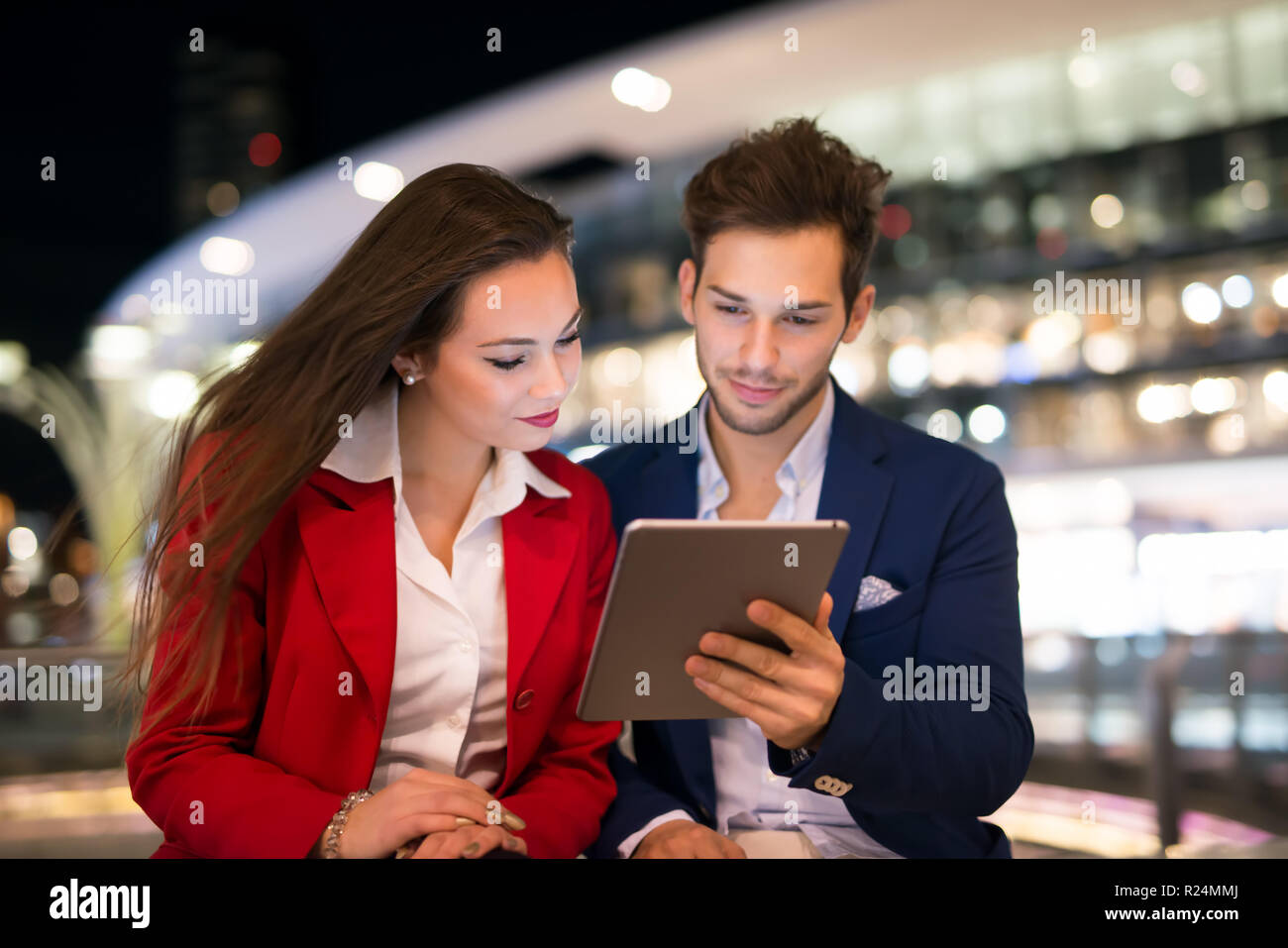 People using tablet at night in a city Stock Photo - Alamy