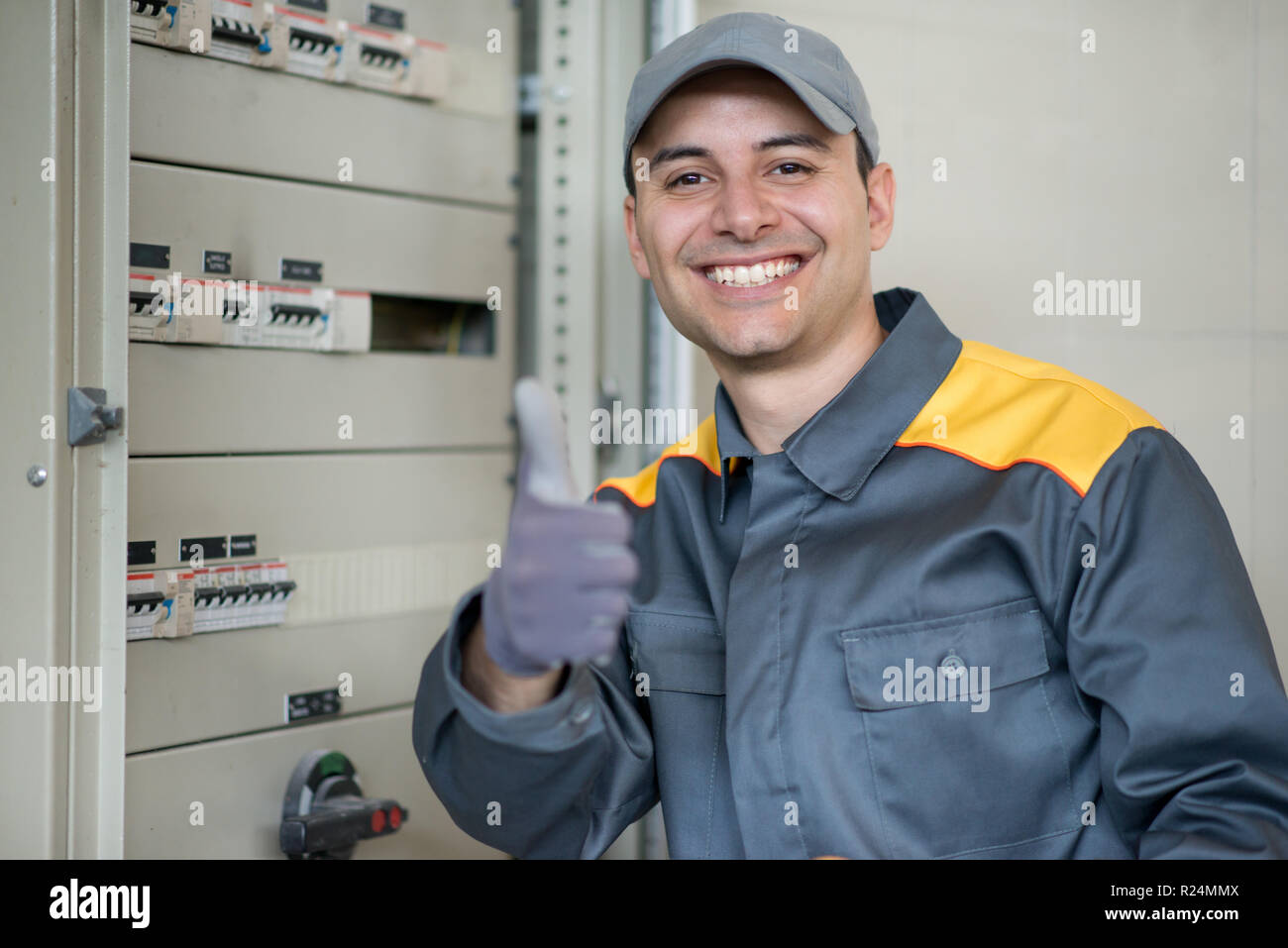 Portrait of a cheerful electrician giving thumbs up Stock Photo - Alamy