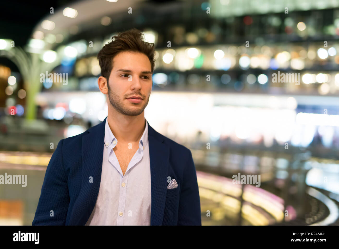 Smiling young man walking outdoors at night Stock Photo - Alamy