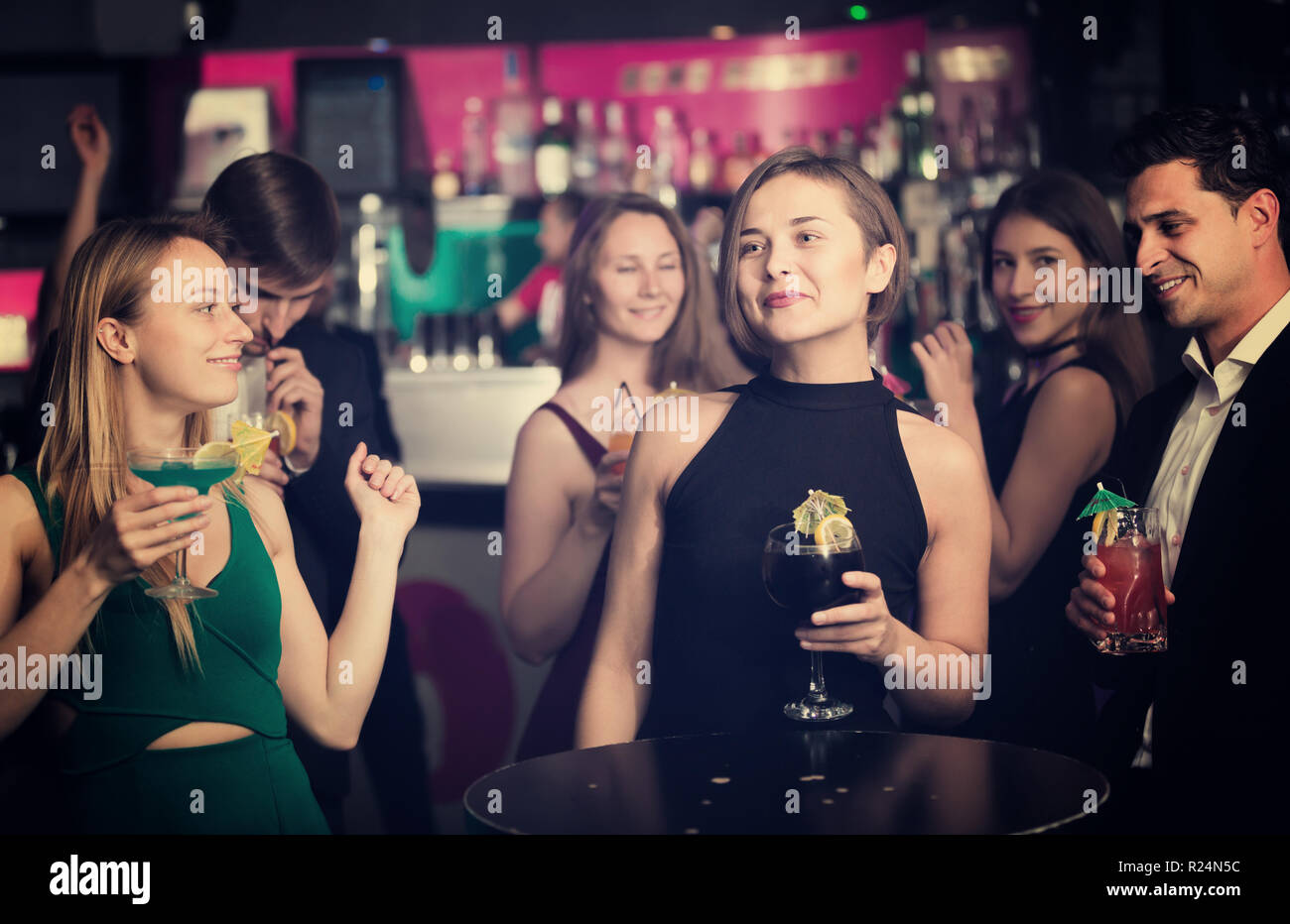 Cheerful colleagues dancing on corporate party with cocktails in hands ...