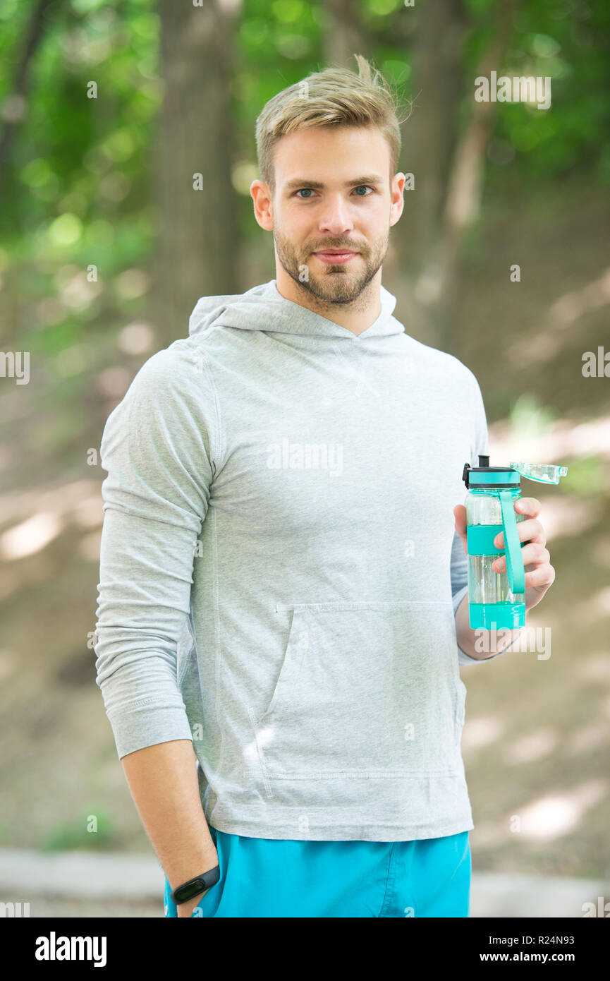 Refreshing vitamin drink after outdoor workout. Man athletic appearance ...