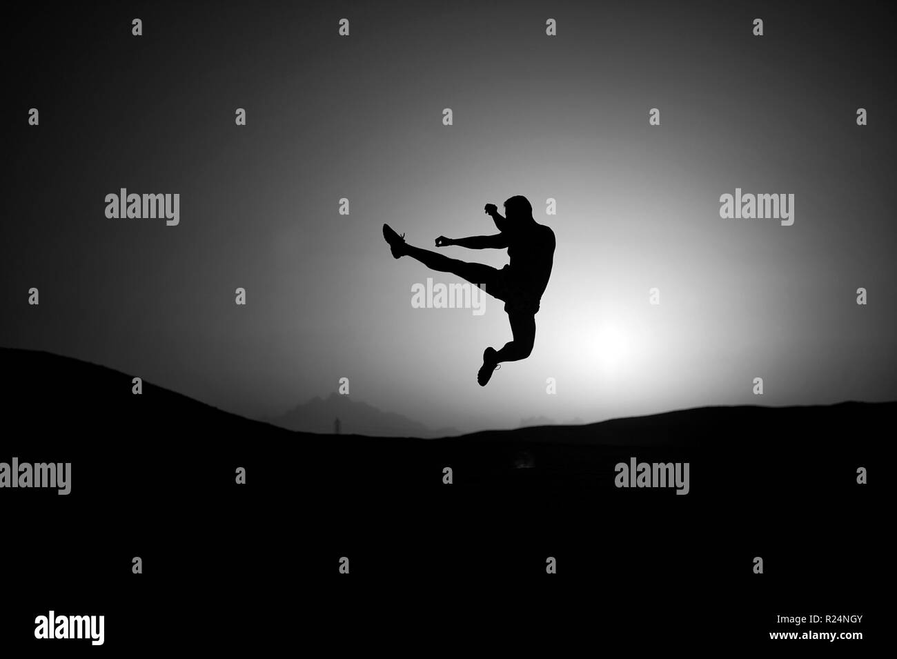 Athlete jump high with energy. Sportsman silhouette on sunset sky. Man ...