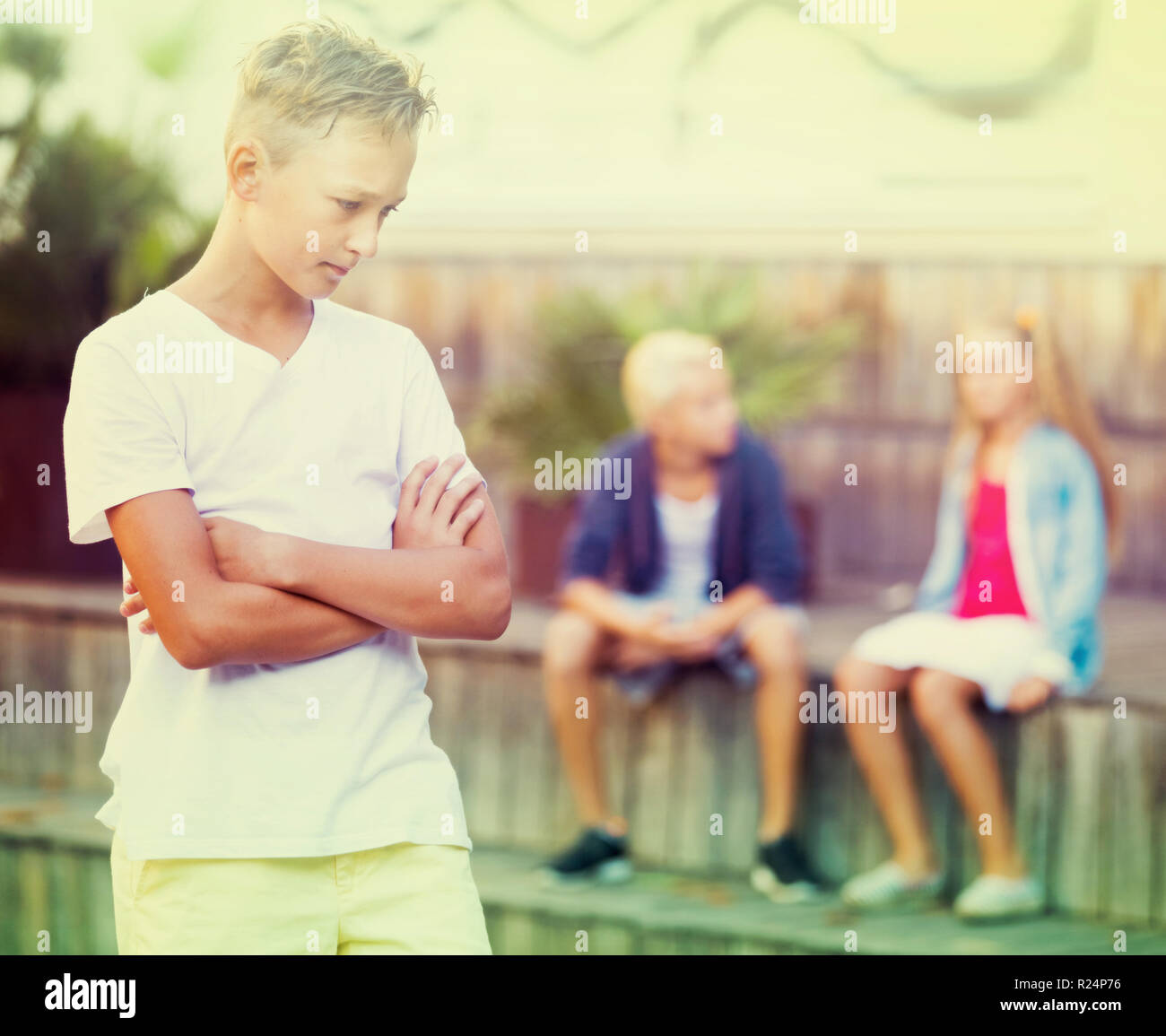 Portrait of offended boy not talking with friends after quarrel ...