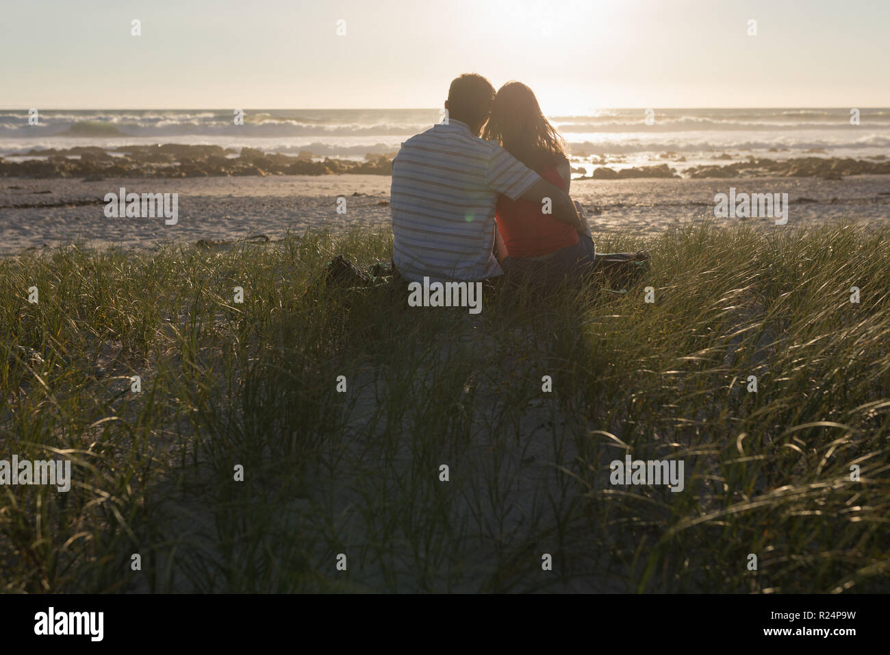 Couple sitting on the beach at sunset hi-res stock photography and ...