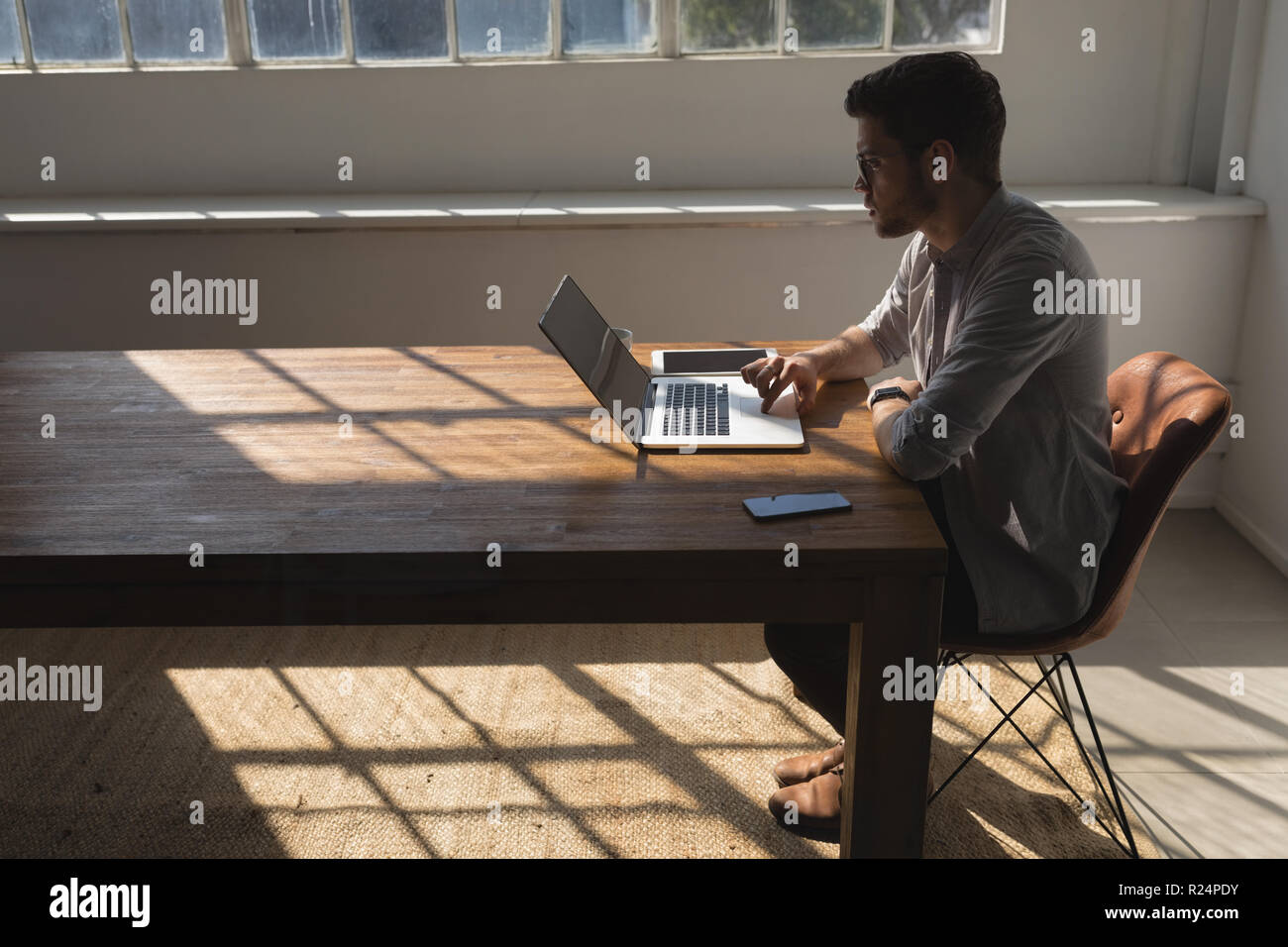 Male executive using laptop in conference room Stock Photo - Alamy