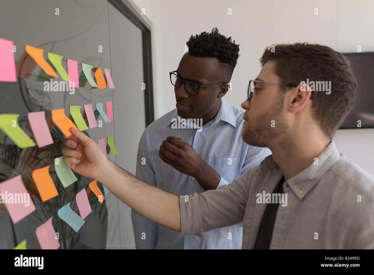 Male executives discussing over sticky notes Stock Photo - Alamy