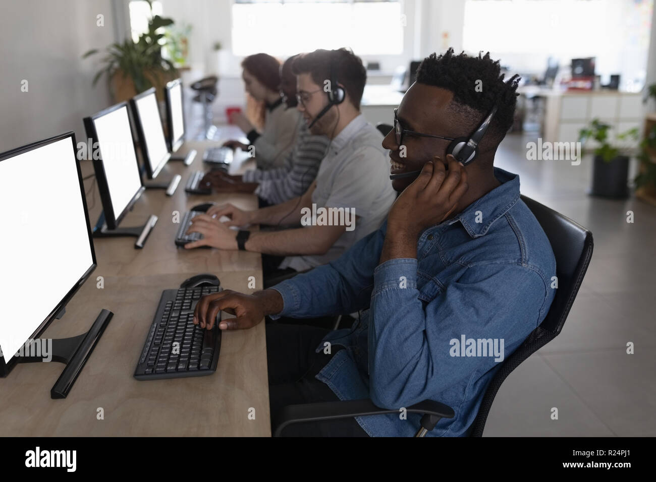 Customer service executives talking on headset at desk Stock Photo - Alamy