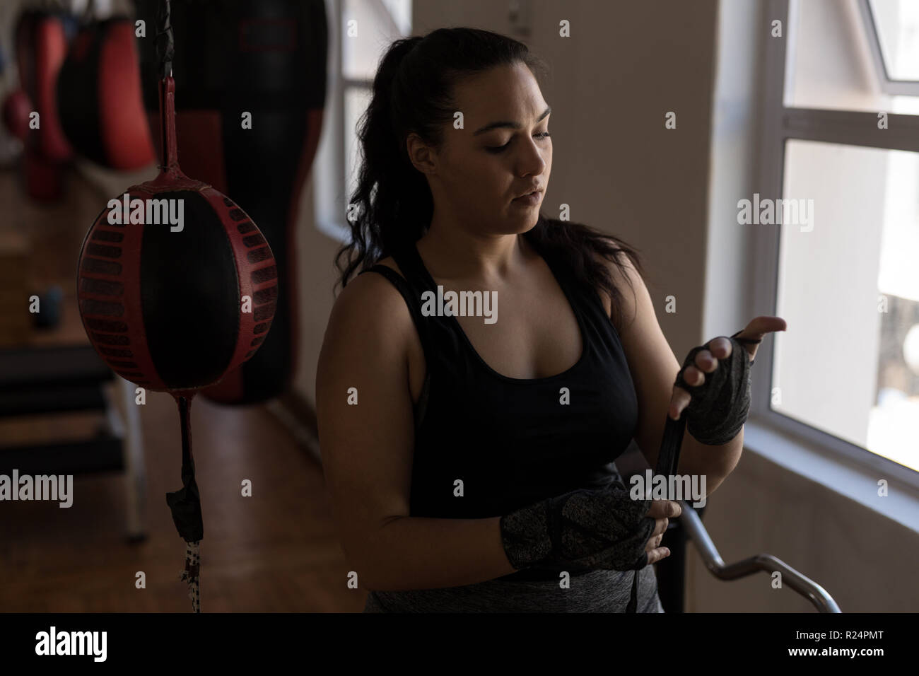 Female boxer wearing hand wrap in fitness studio Stock Photo - Alamy
