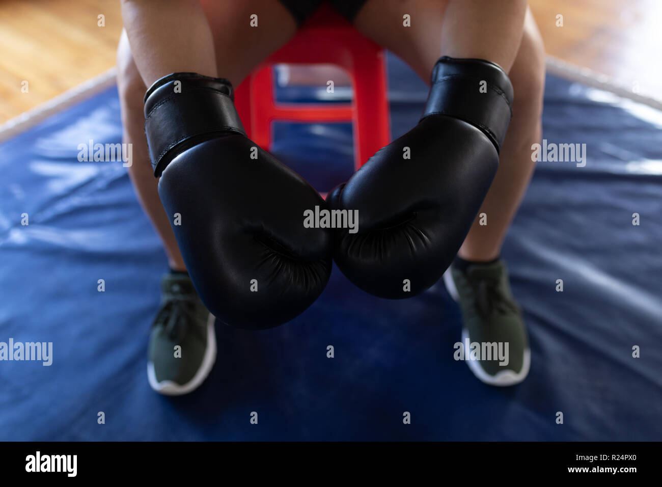 Female boxer sitting with boxing gloves in fitness studio Stock Photo ...